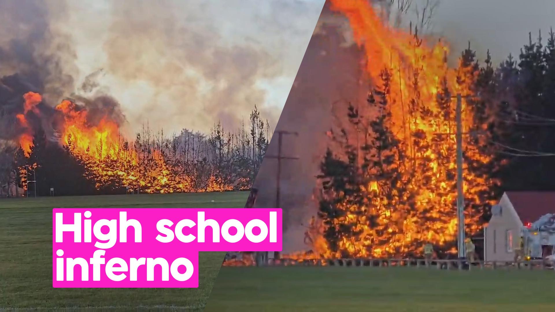 Flames tower above high school's tree line in massive vegetation fire